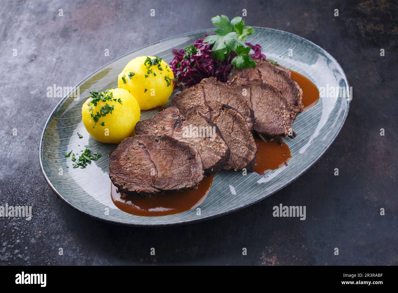Traditional braised marinated German Sauerbraten from beef with blue ...