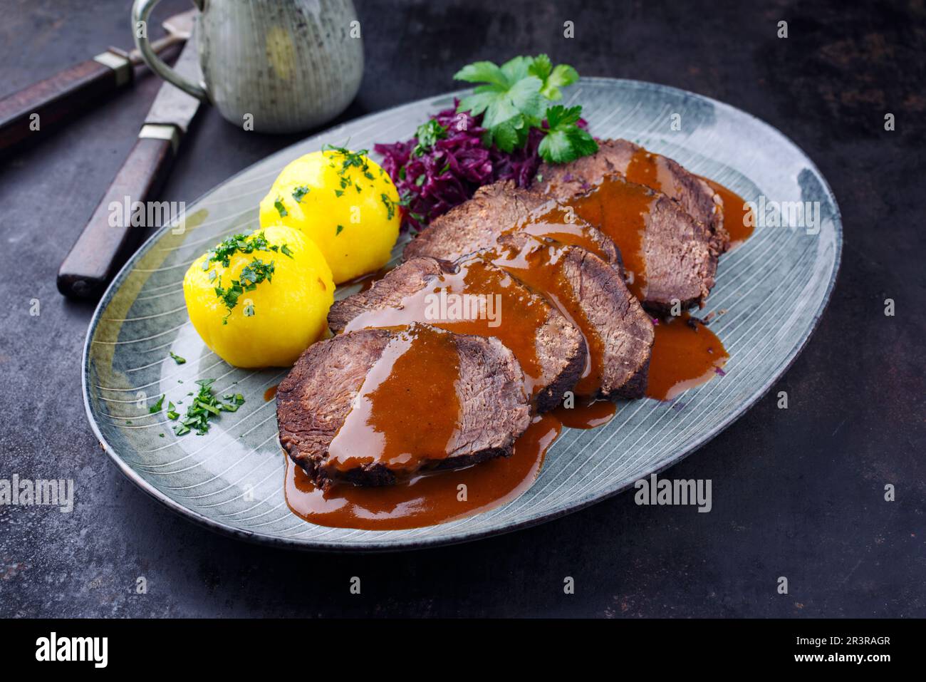 Traditional braised marinated German Sauerbraten from beef with blue ...