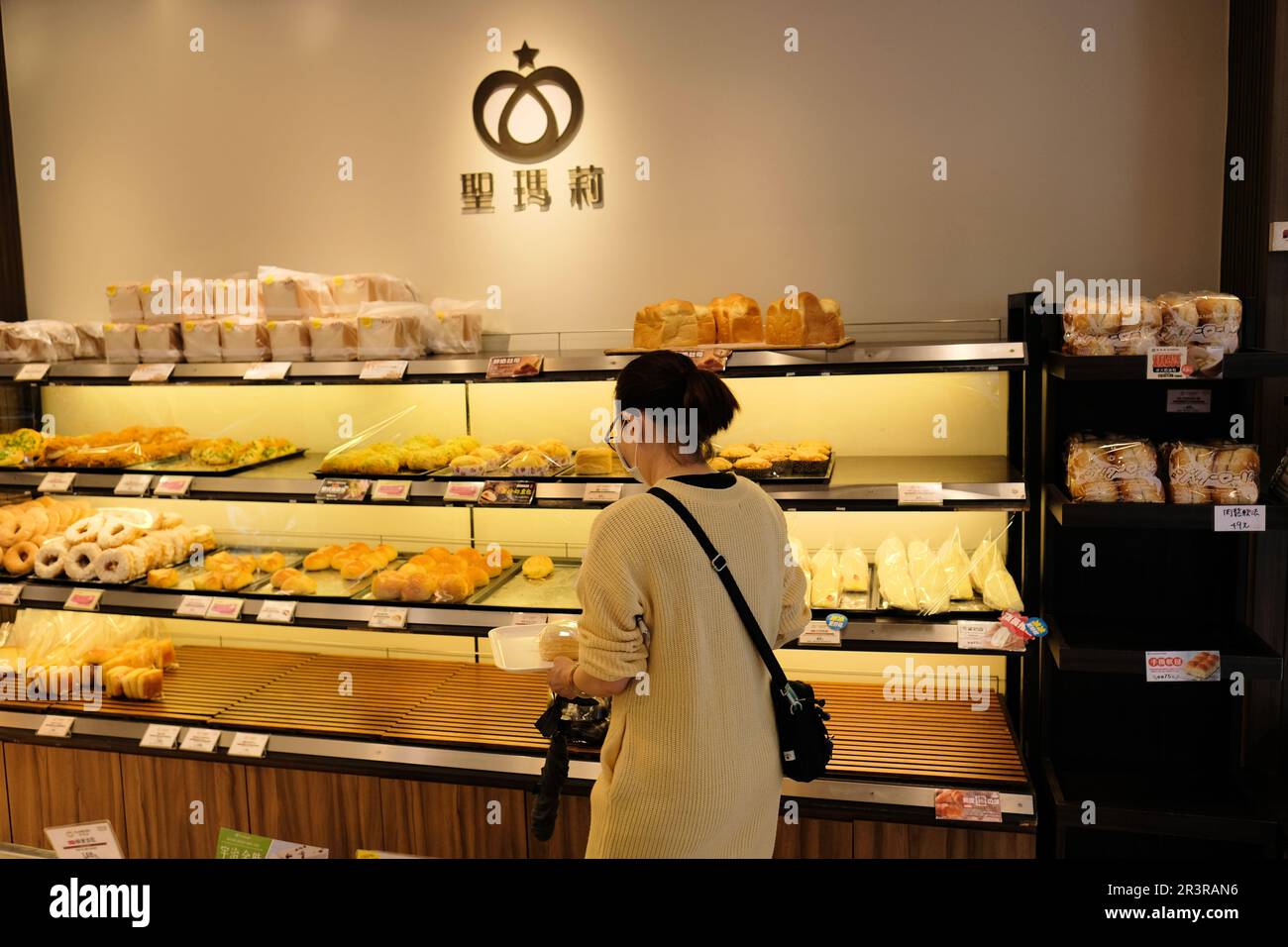 Customer selecting pastries from trays and display cases at a Sunmerry ...