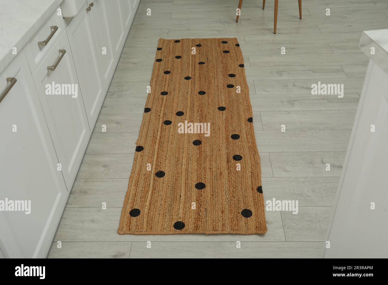 Stylish rug with dots on floor in kitchen Stock Photo - Alamy