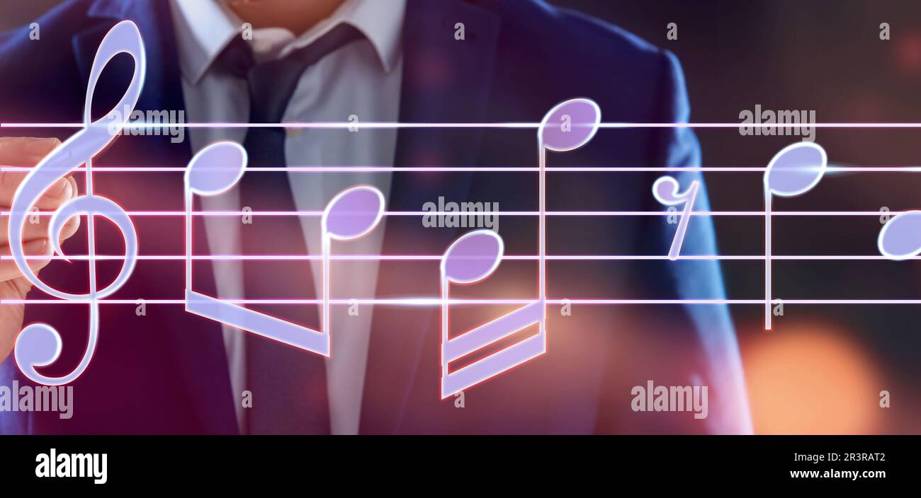 Man with pen writing staff with music notes and symbols on color ...