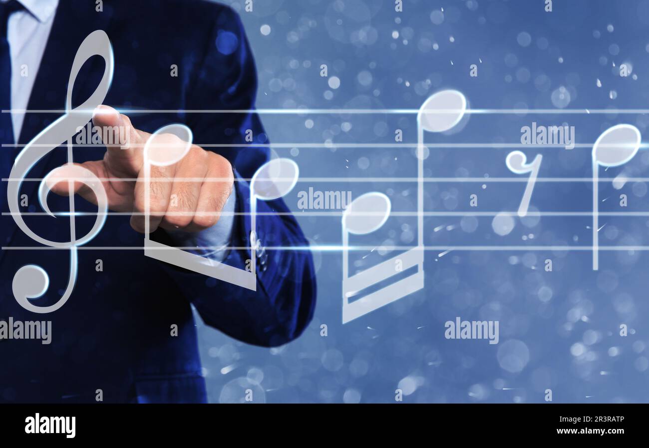 Musician pointing at staff with music notes and symbols on color ...