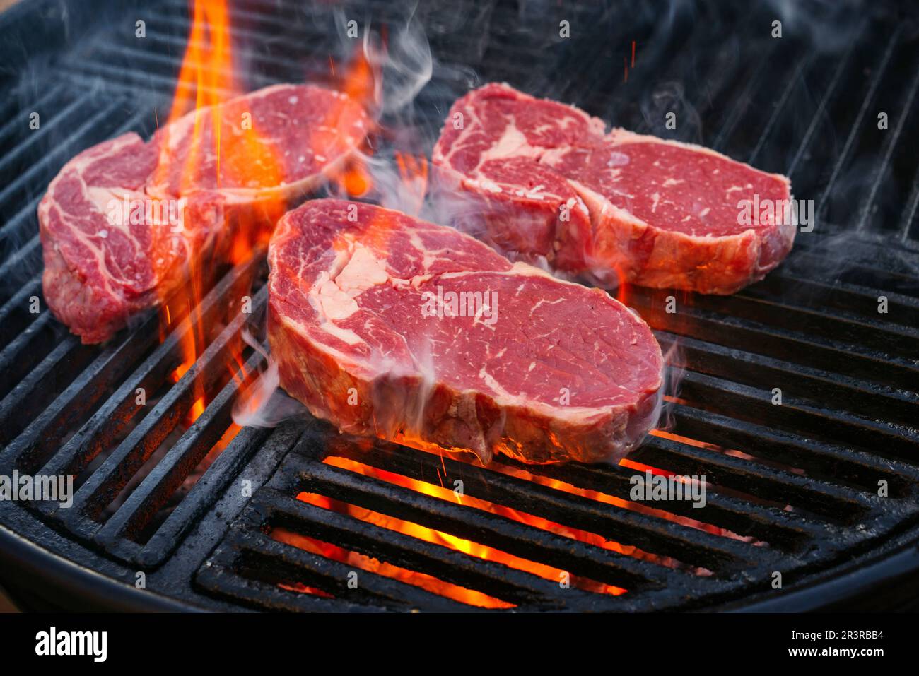 Barbecue dry aged angus rib-eye beef steak grilled as close-up on a ...