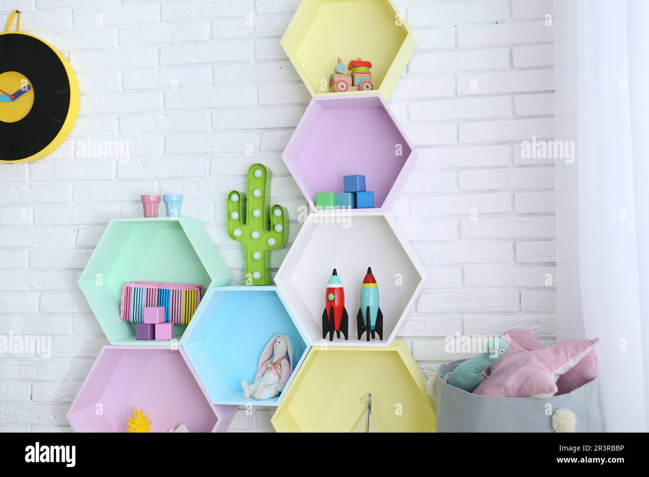 Colorful shelves near brick wall in child room interior Stock Photo - Alamy