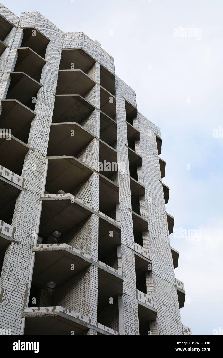 Construction site with unfinished building under cloudy sky, low angle ...