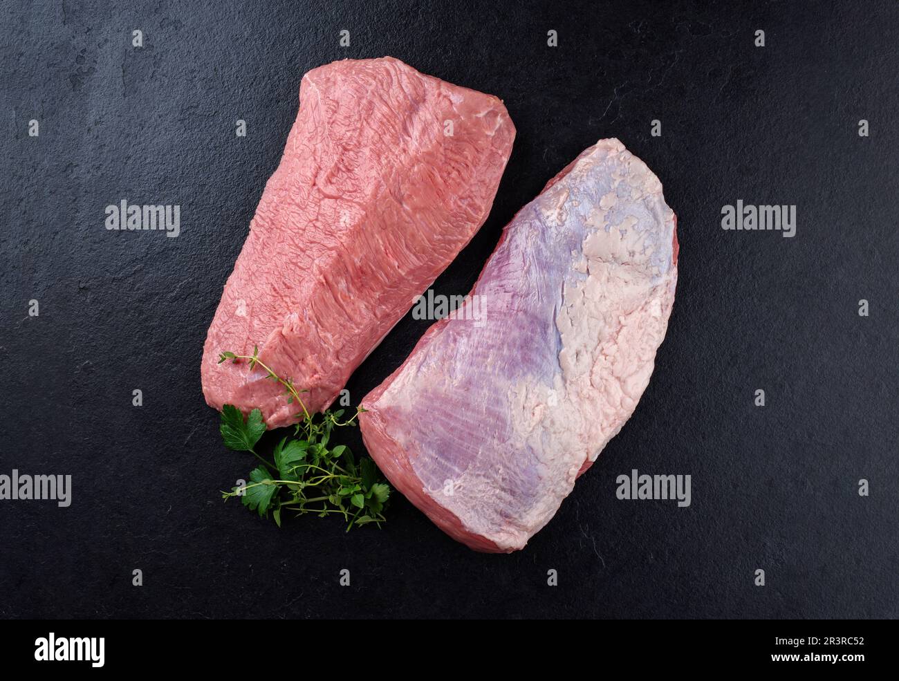 Raw cap of rump calf offered as top view on a black board with copy ...