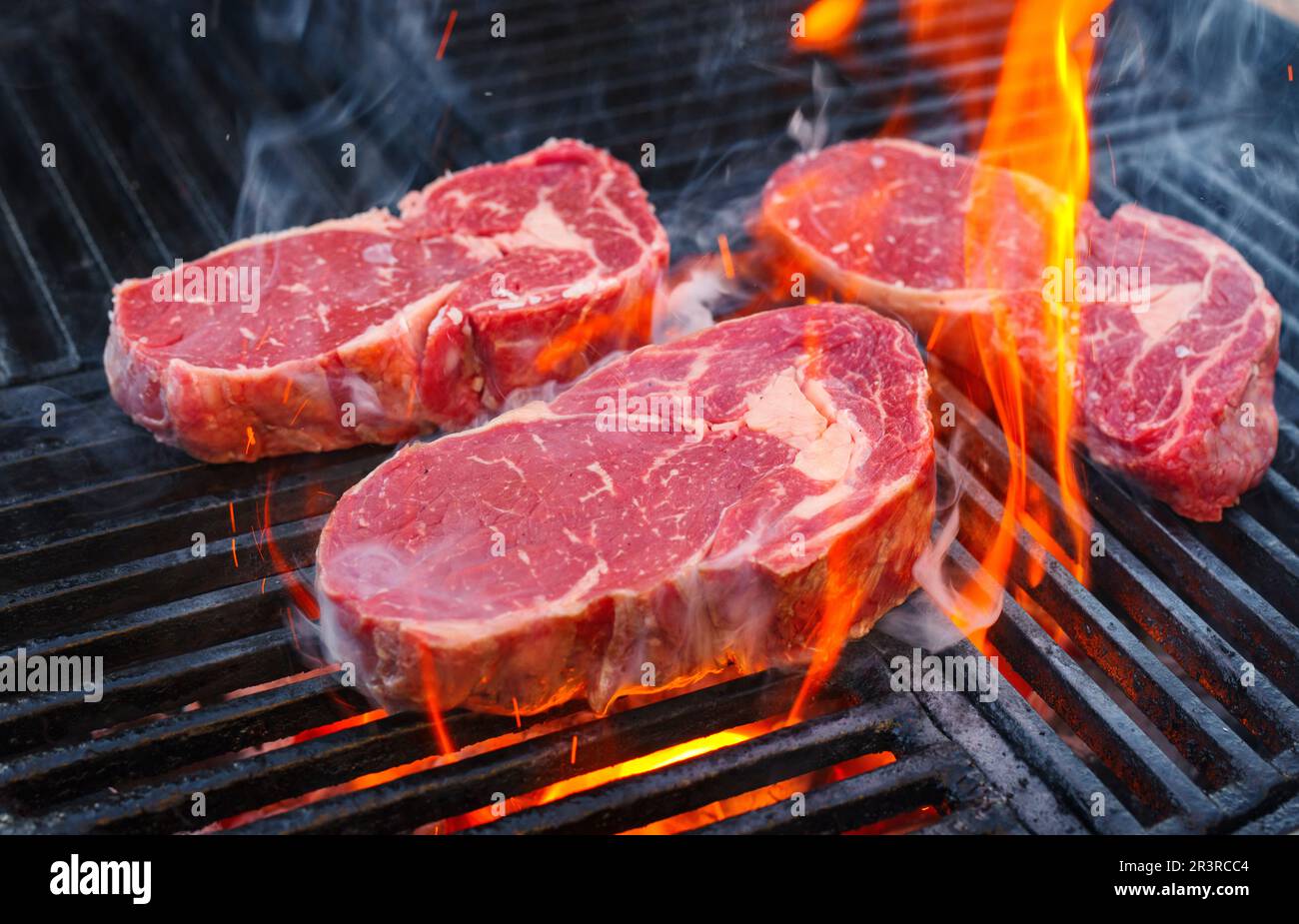 Barbecue dry aged angus rib-eye beef steak grilled as close-up on a ...