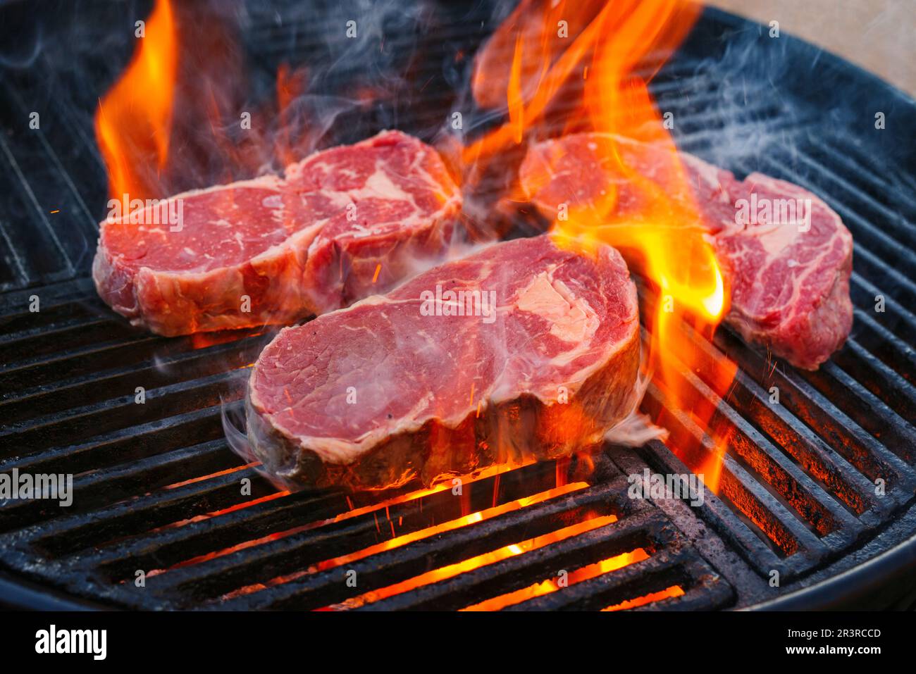 Barbecue dry aged angus rib-eye beef steak grilled as close-up on a ...