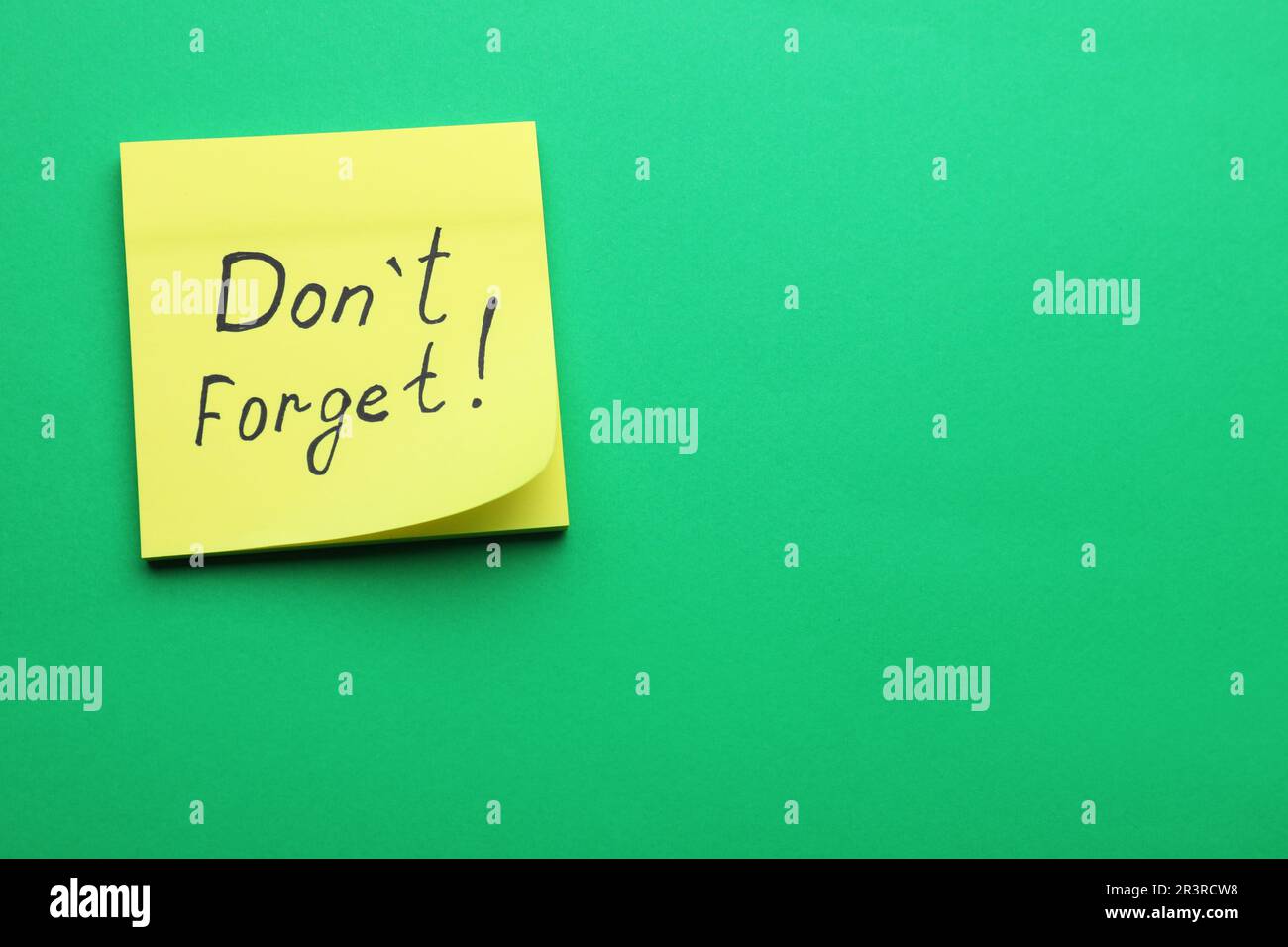 Paper note with phrase Don't Forget on green background, top view ...