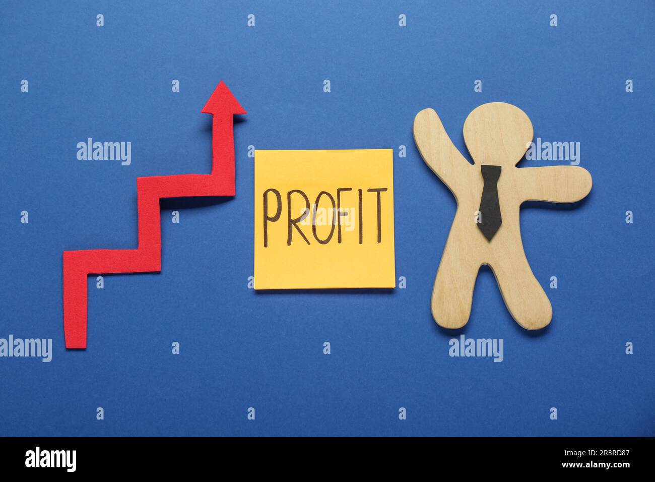 Sticky note with word Profit, up arrow and wooden human figure on blue ...