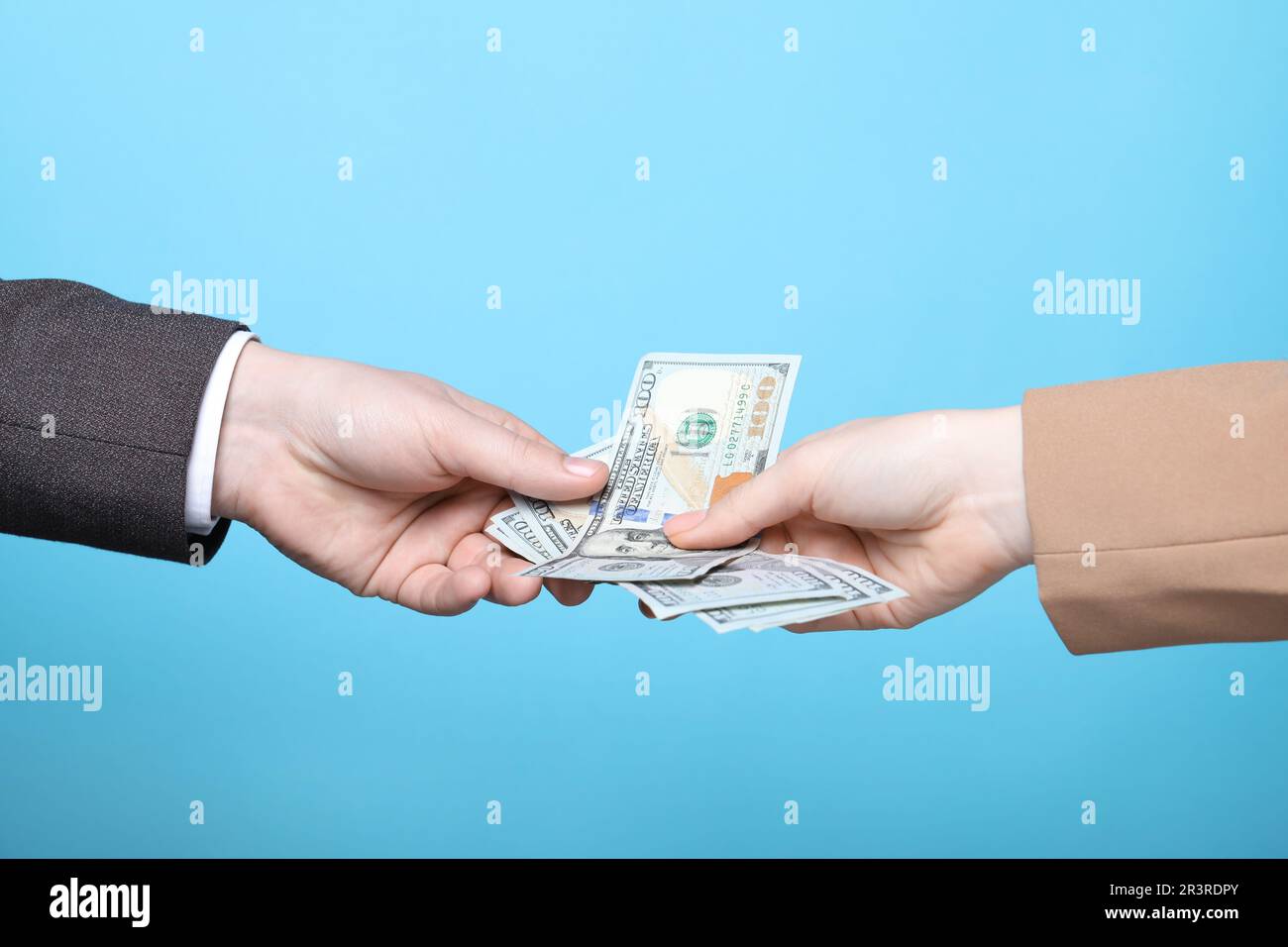 Man giving money to woman on light blue background, closeup. Currency ...