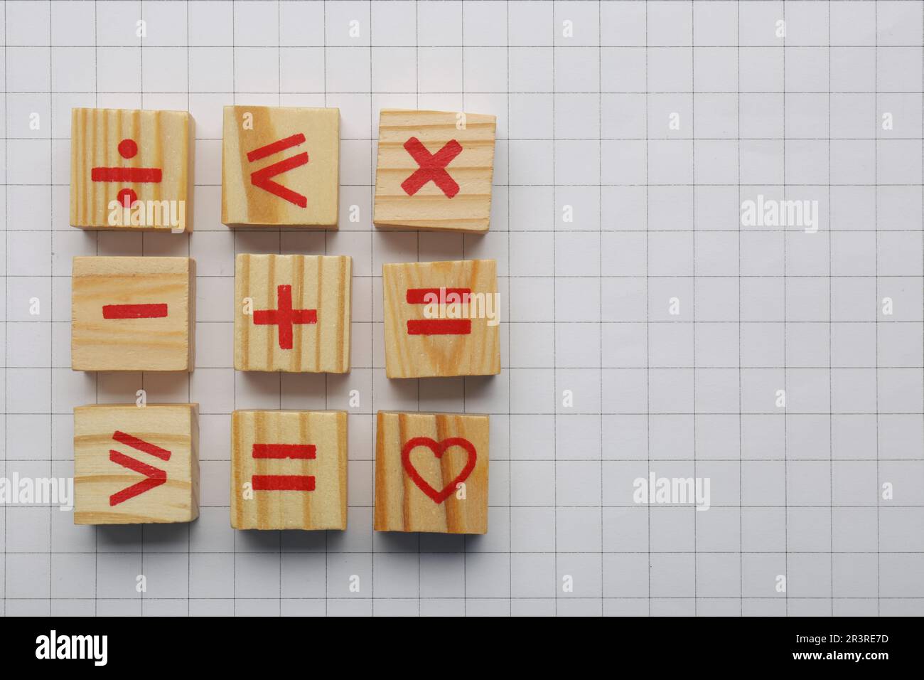 Wooden cubes with mathematical symbols and heart on sheet of grid paper ...