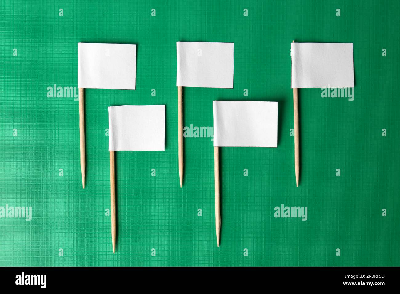 Many white paper flags on green background, flat lay Stock Photo - Alamy