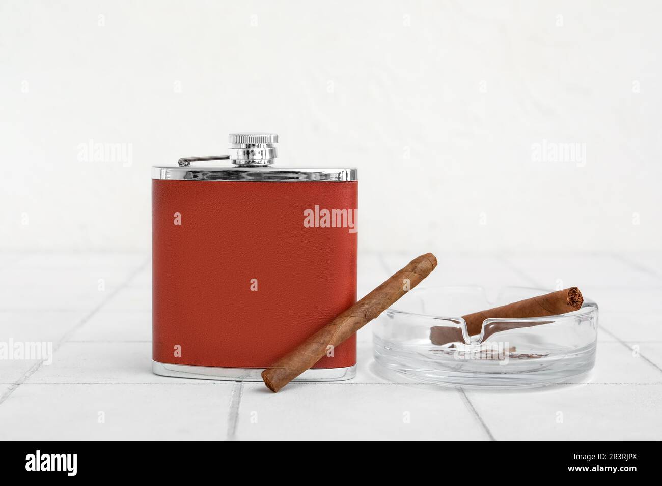 New hip flask and ash tray with cigars on table Stock Photo - Alamy
