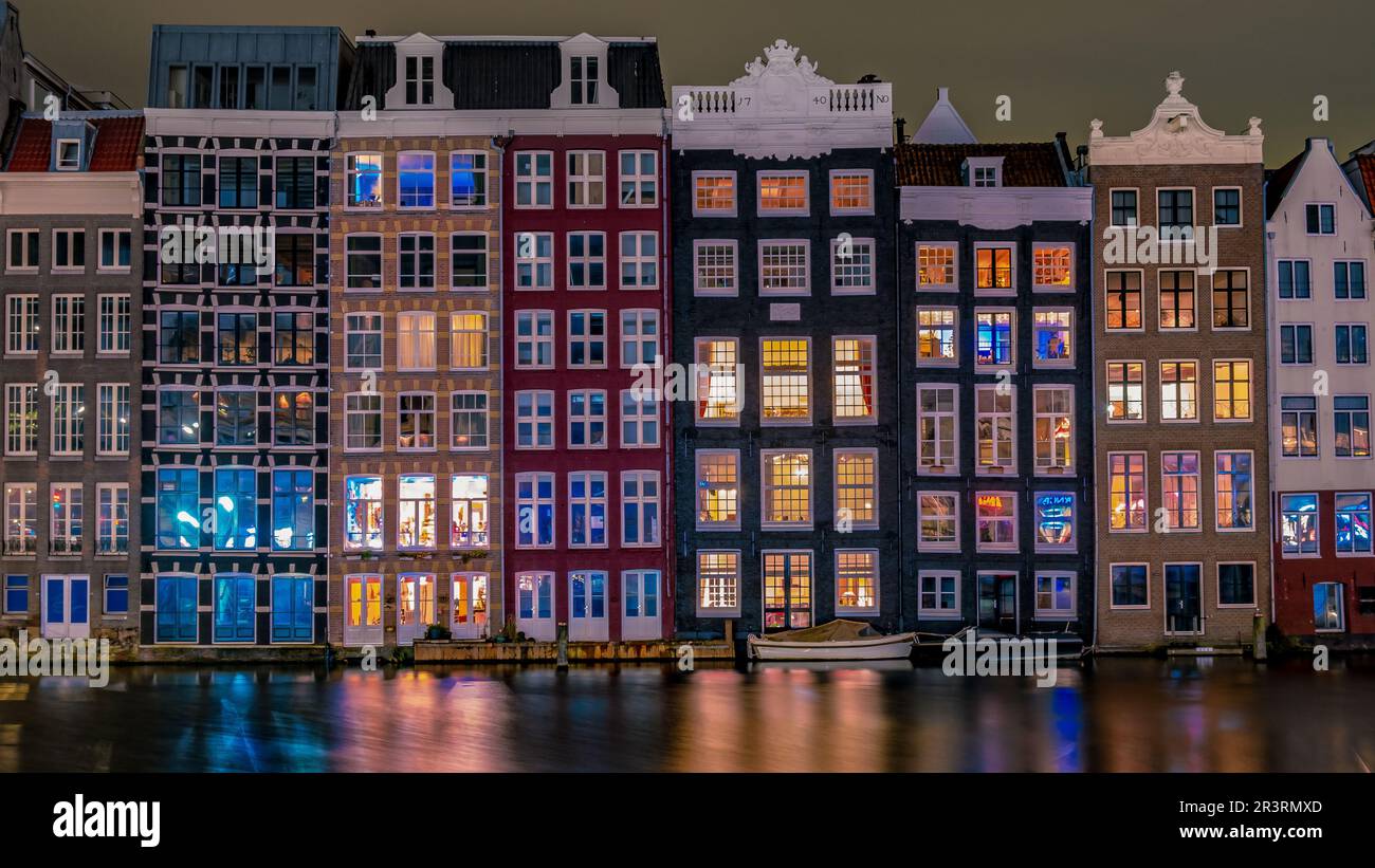 Amsterdam at night with dancing colorful house at the Amsterdam canals ...