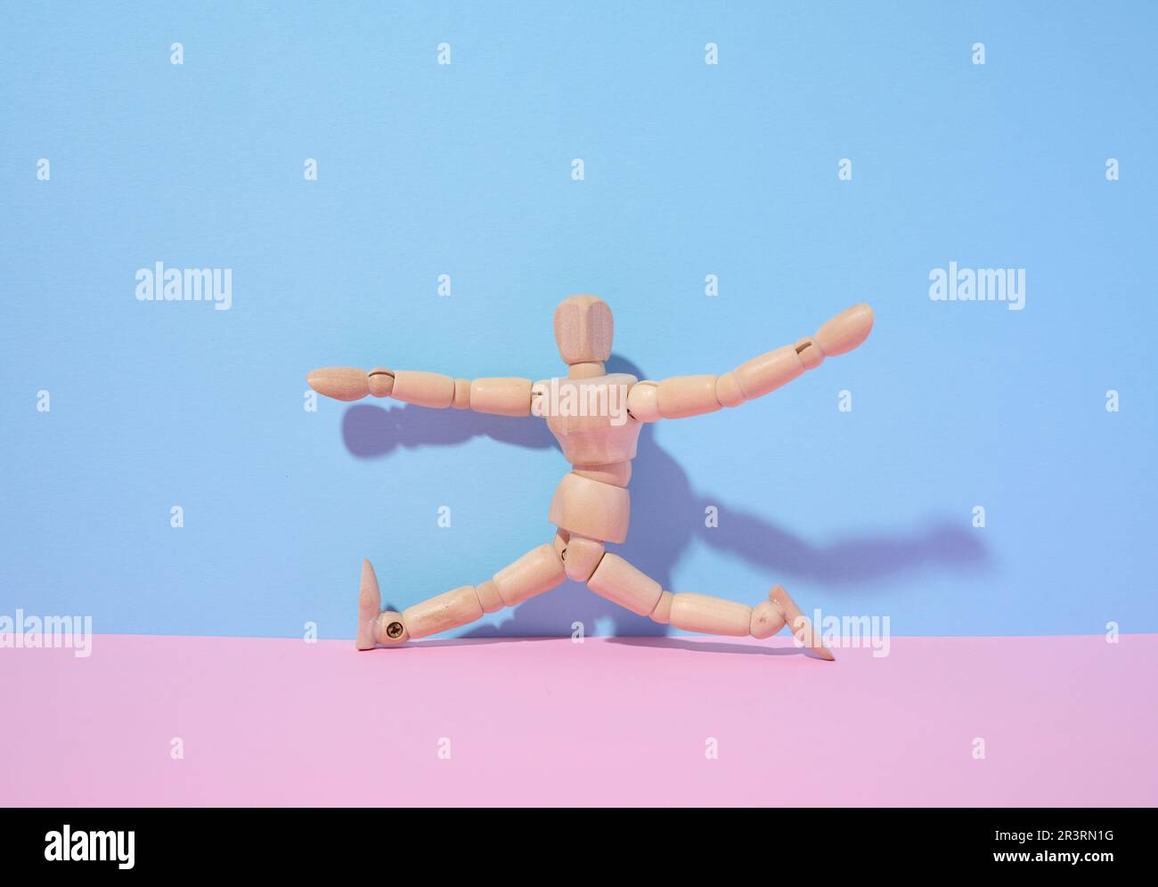 Wooden puppet man on a blue background, a pose in a twine. Sports Stock ...