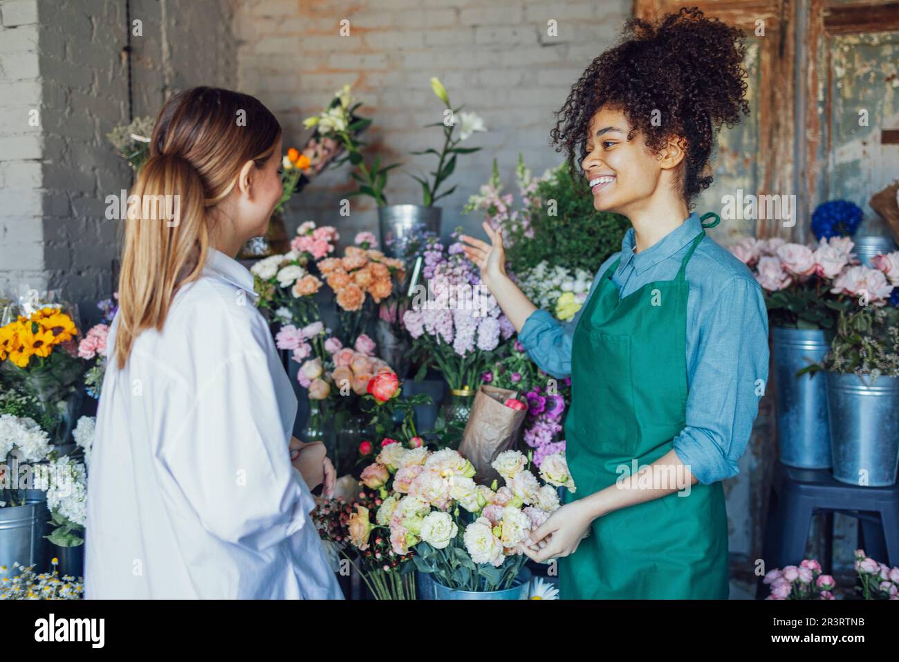 Happy black woman entrepreneur standing in plant store selling fresh ...