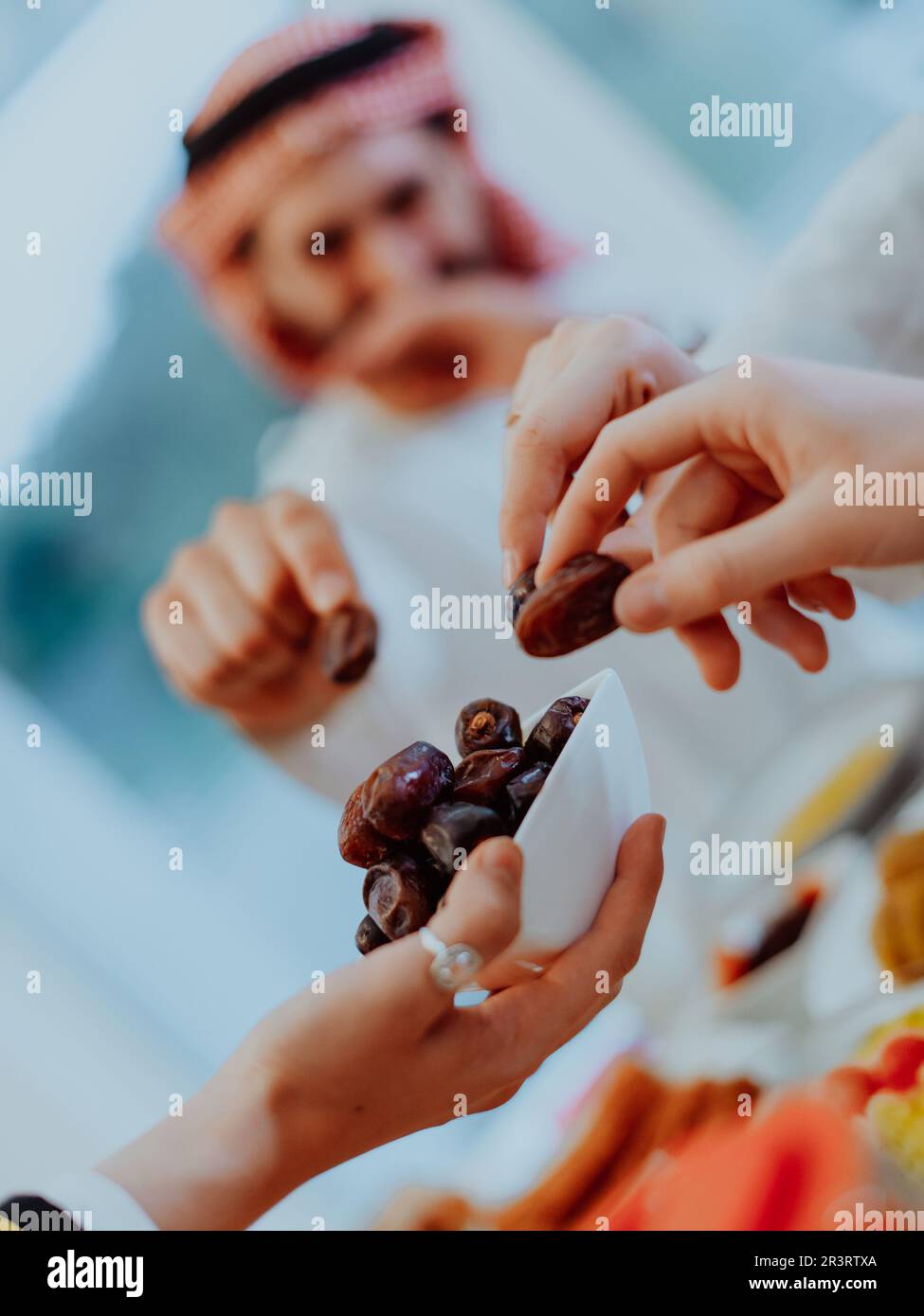 Modern multiethnic muslim family sharing a bowl of dates while enjoying ...