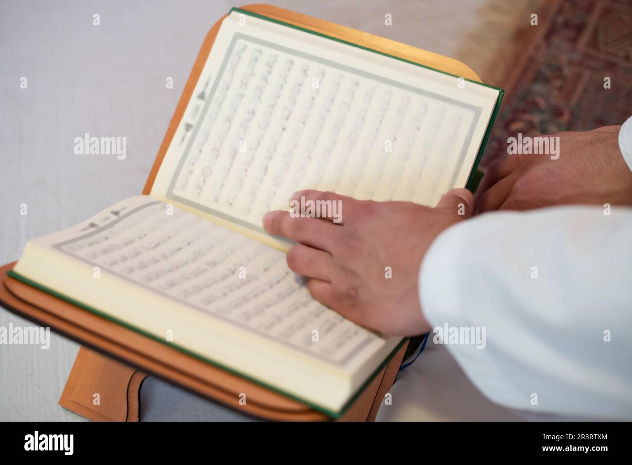 Young arabian muslim man in traditional clothes reading holy book Quran ...