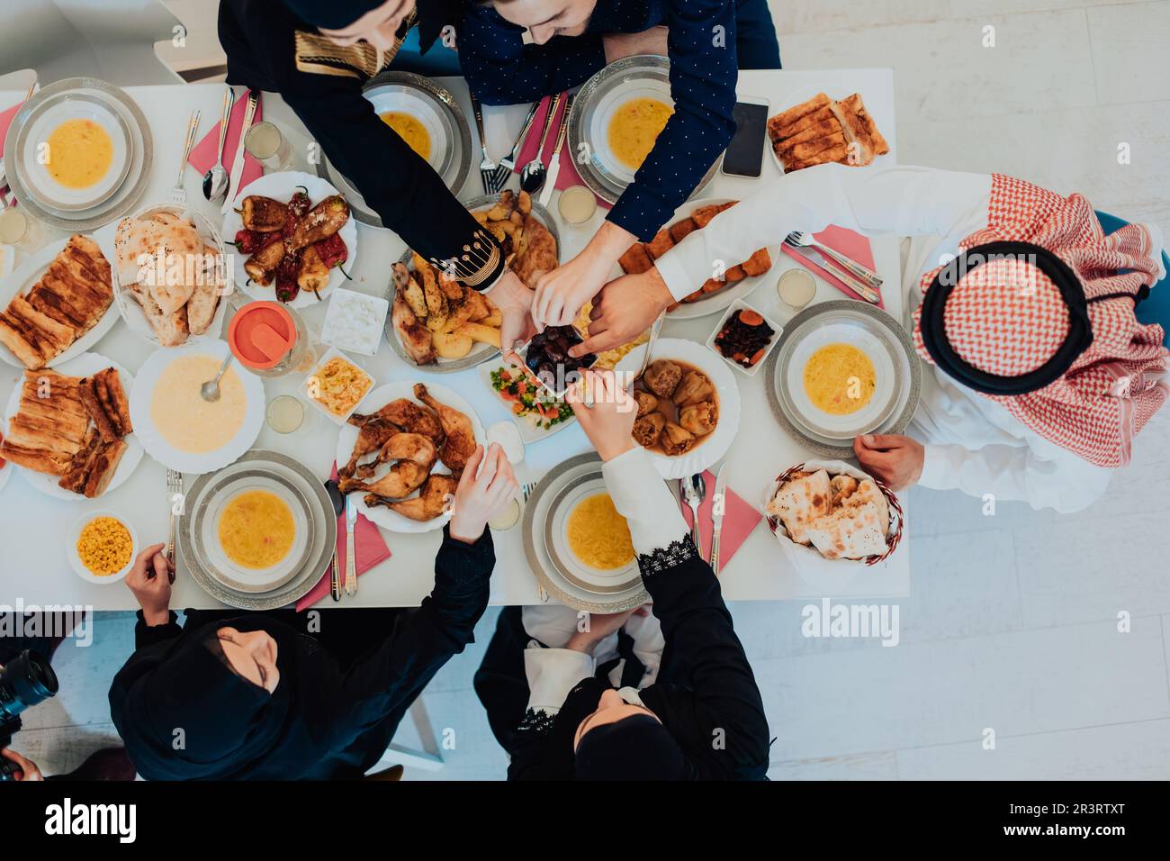 Muslim family having Iftar dinner drinking water to break feast. Eating ...
