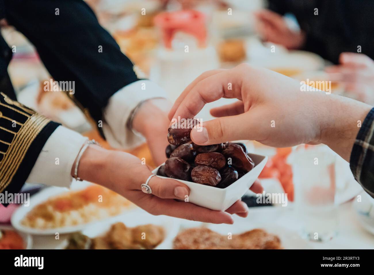 Modern multiethnic muslim family sharing a bowl of dates while enjoying ...