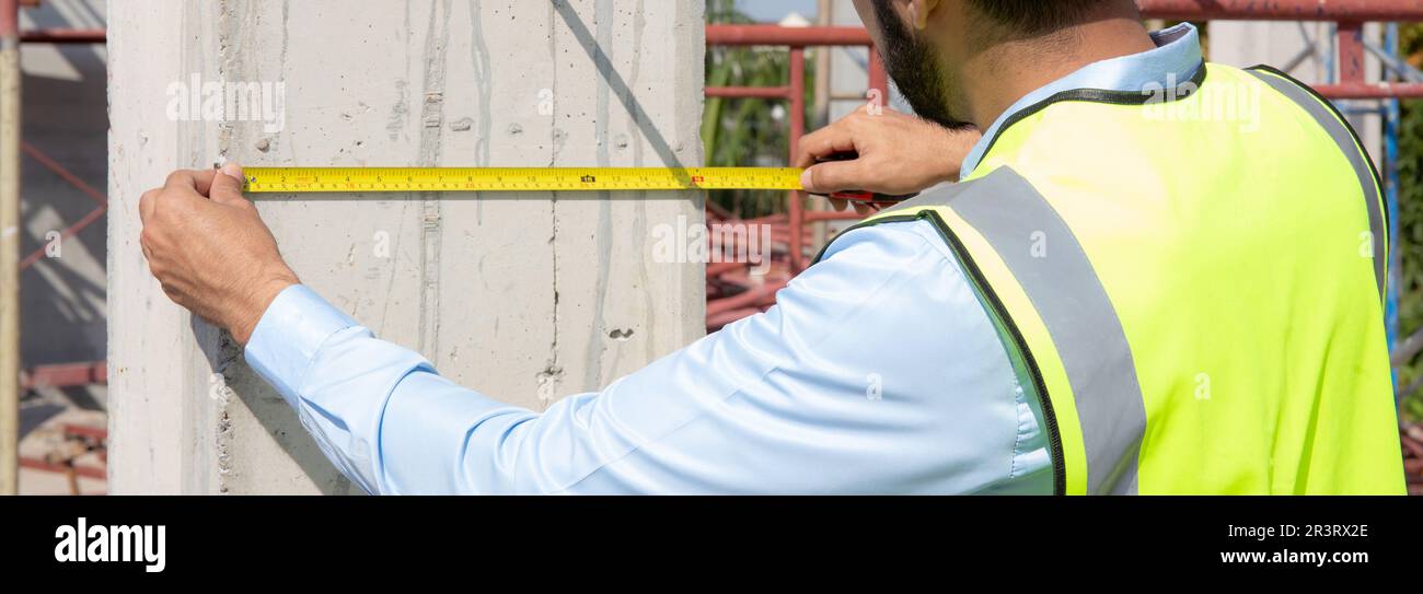 Engineer young man using tape measure for check and examining length of ...