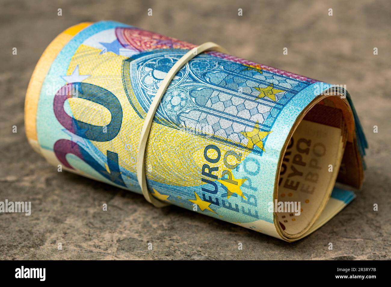 Roll of euro banknotes with a rubber band Stock Photo - Alamy