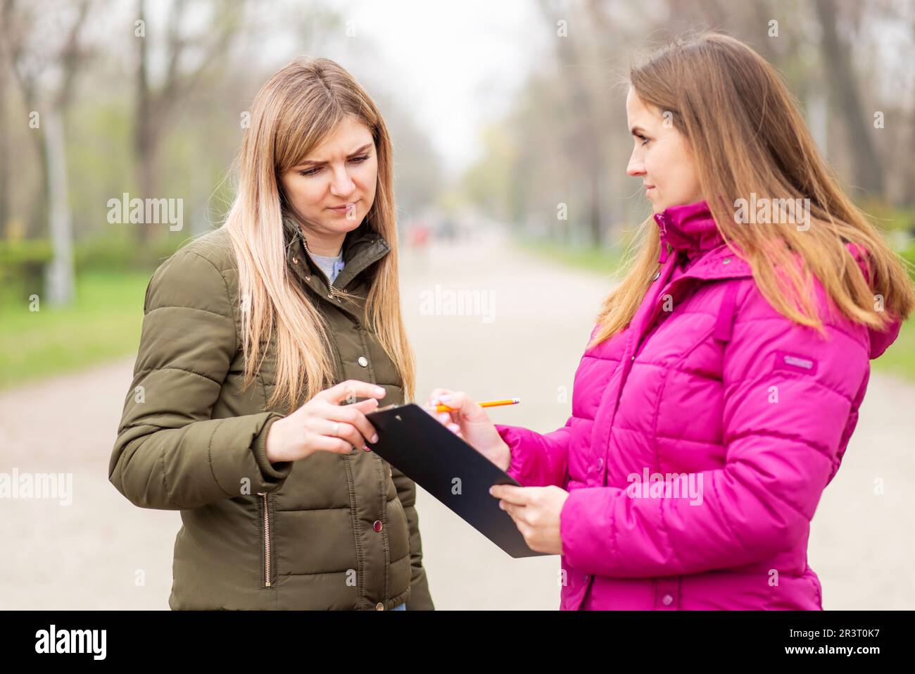 Opinion poll. A woman interviewing people, conducting survey standing ...