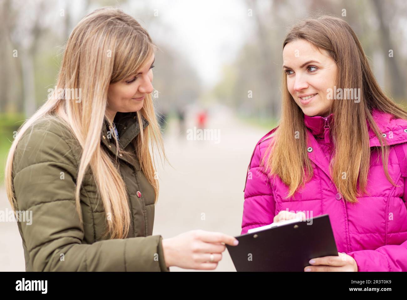 Opinion poll. A woman interviewing people, conducting survey standing ...