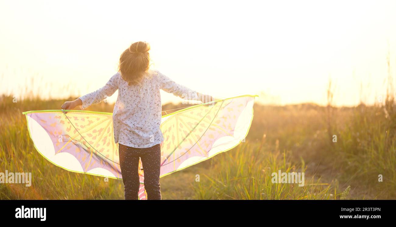 Girl is standing with wings in field, learning to fly a kite . Outdoor ...