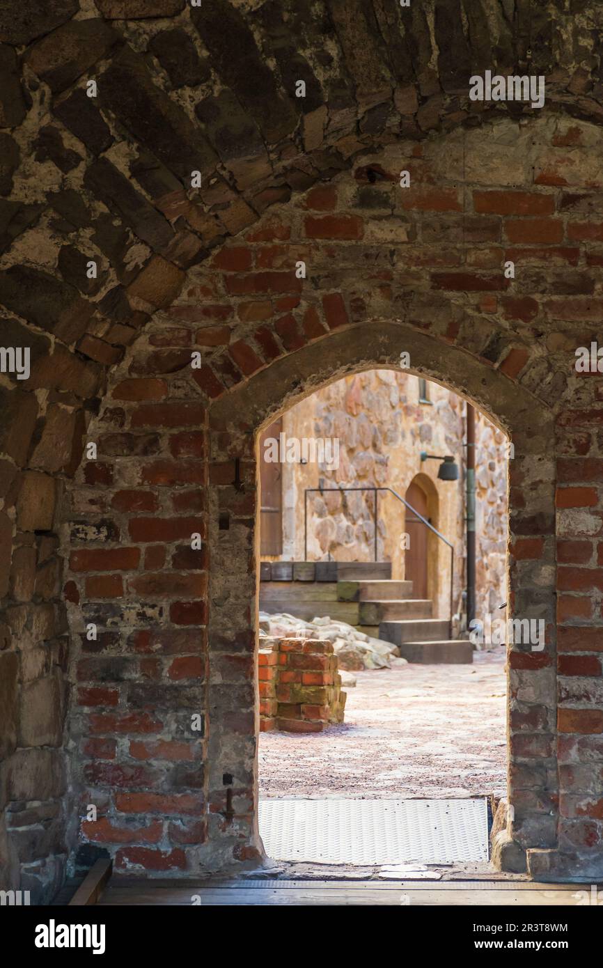 Arched doorway in stone and brick wall to the courtyard of medieval ...