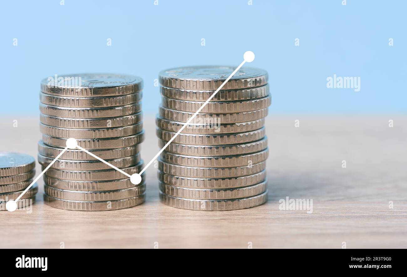 A stack of metallic coins and a chart with growing rates. High income ...