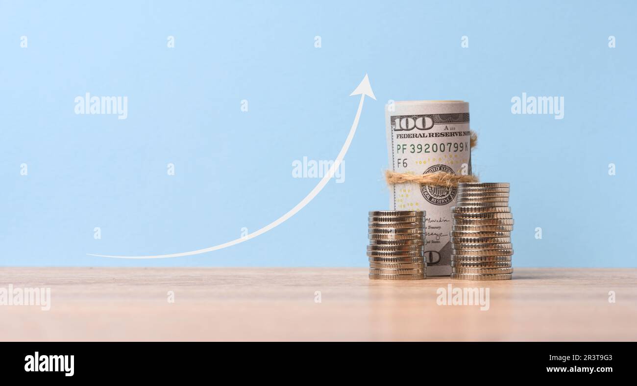 Stack of metallic coins and a graph on a blue background. Income growth ...