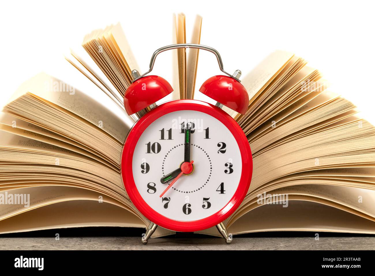 Alarm clock and open book Stock Photo - Alamy