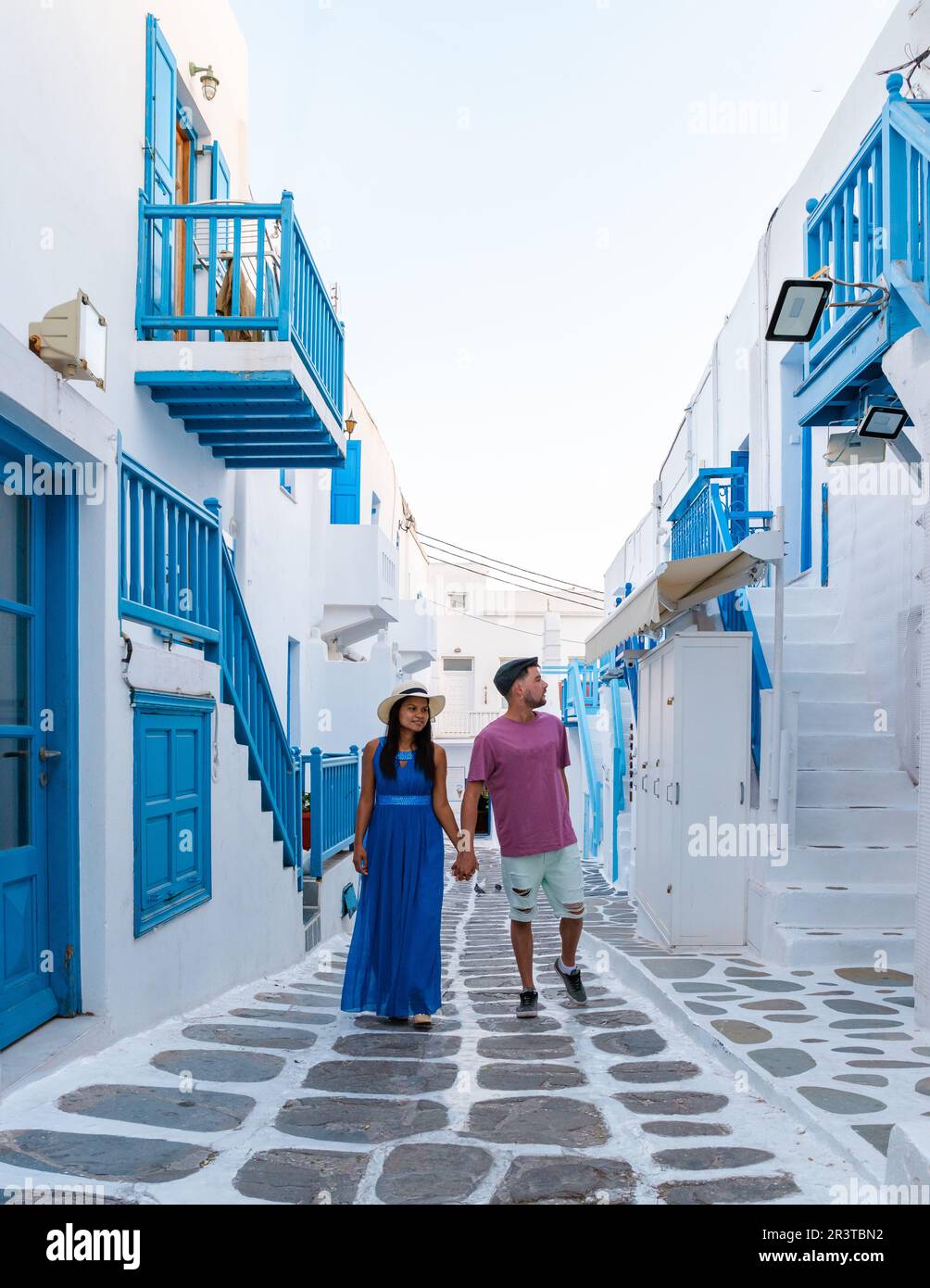 Romantic couple of men and women at the street of Mykonos Greek village ...