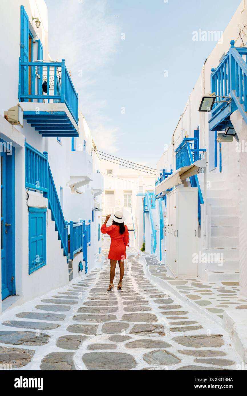 Young women at the street of Mykonos Greek village in Greece, colorful ...
