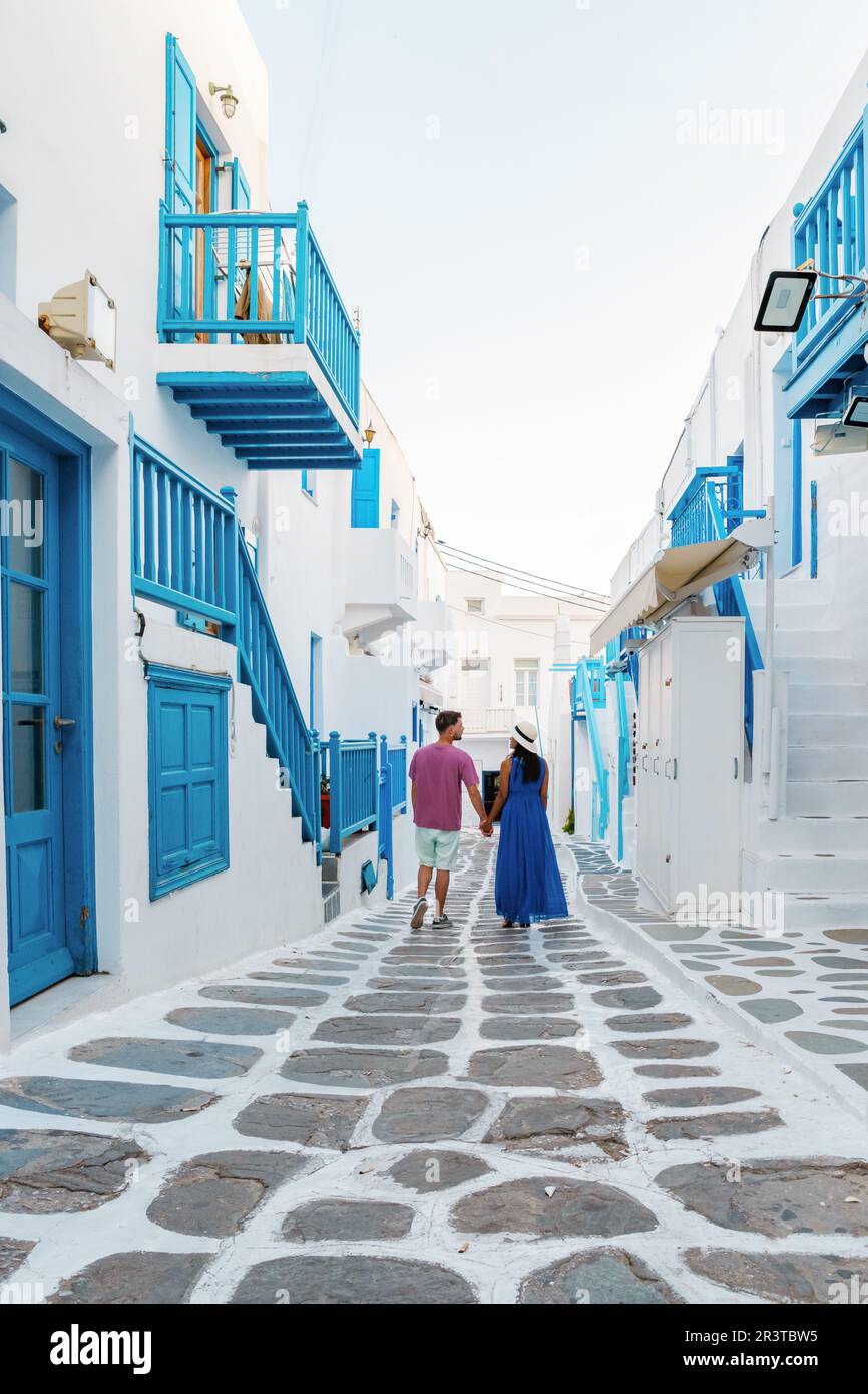 Romantic couple of men and women at the street of Mykonos Greek village ...