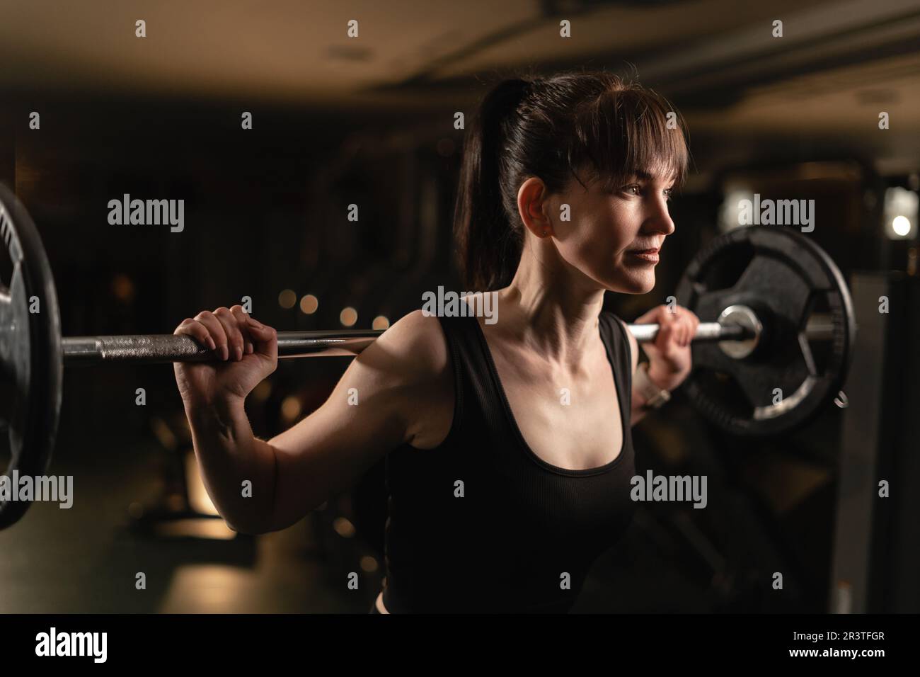 Fitness woman doing exercise with heavy weight bar in the gym. Female ...