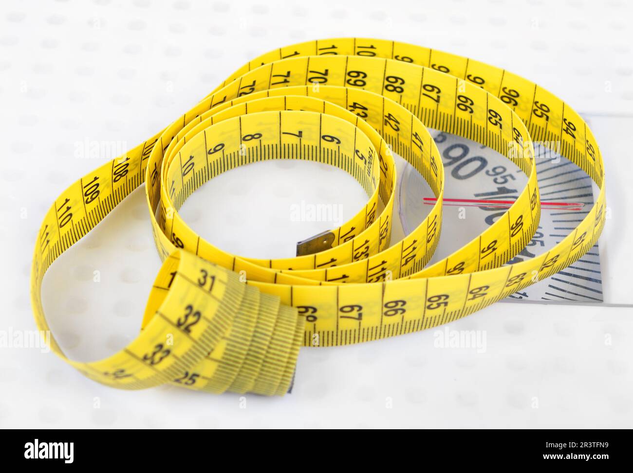 Measuring tape on scales Stock Photo - Alamy