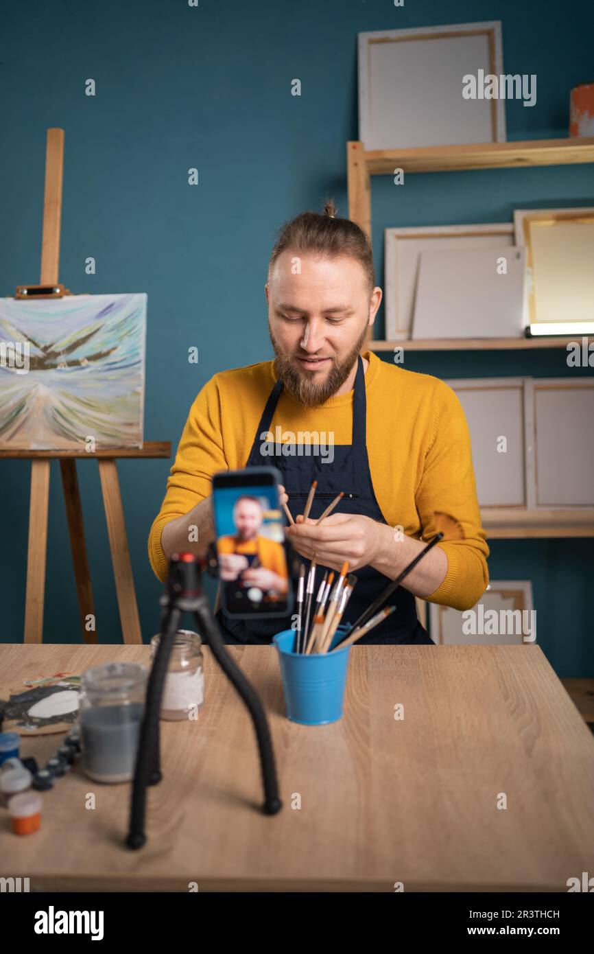 Creative man vlogging his painting technique and skill in art studio ...
