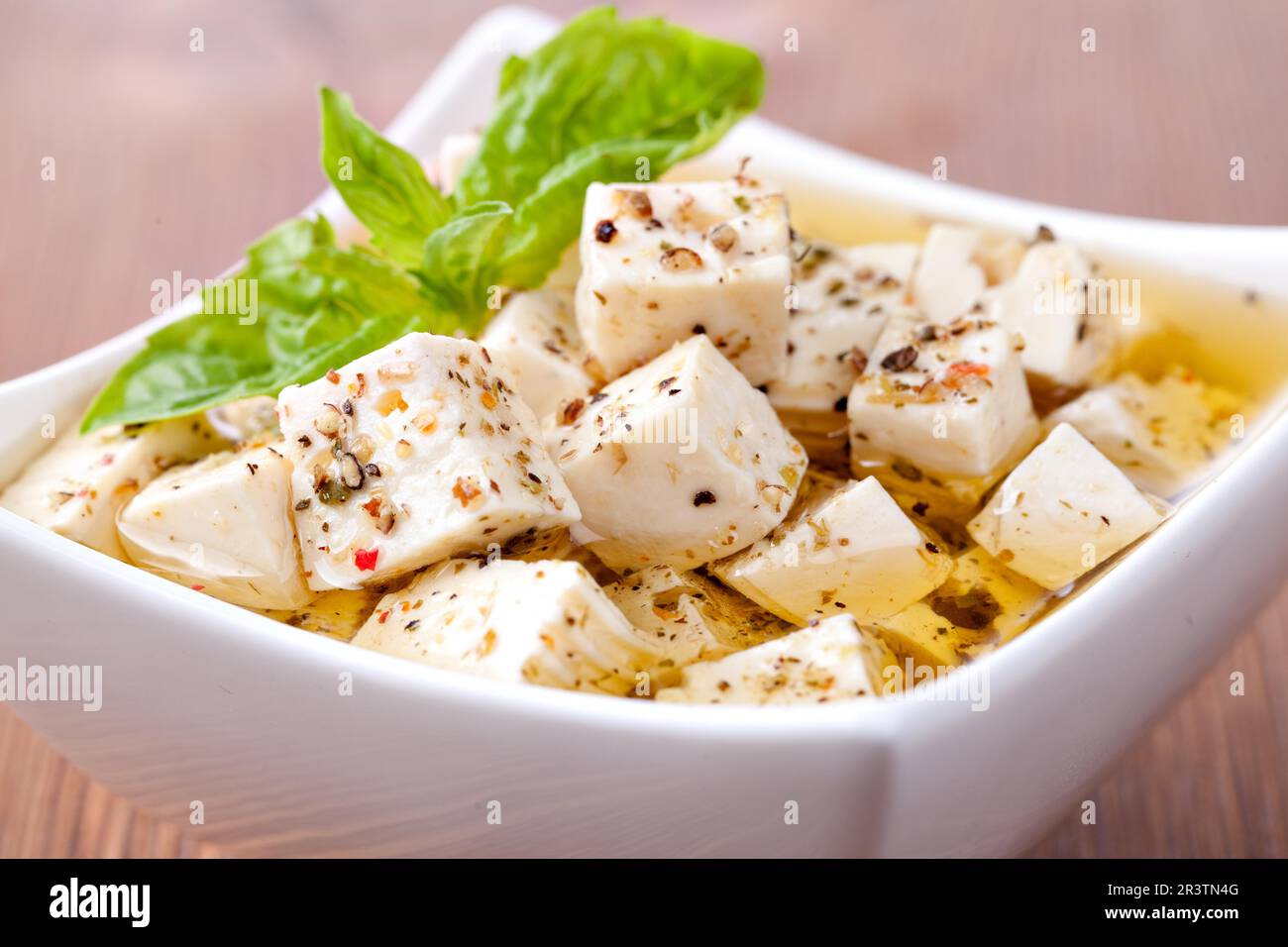 Cubed feta cheese on wooden cutting board Stock Photo - Alamy