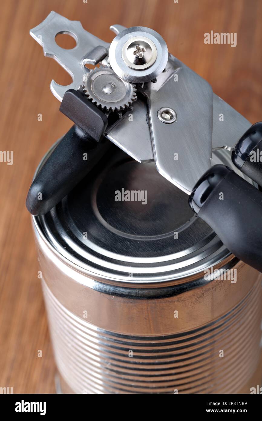 Tin opener opening a can Stock Photo - Alamy