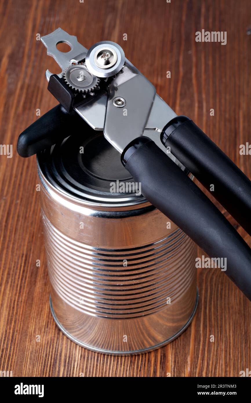 Tin opener opening a can Stock Photo - Alamy