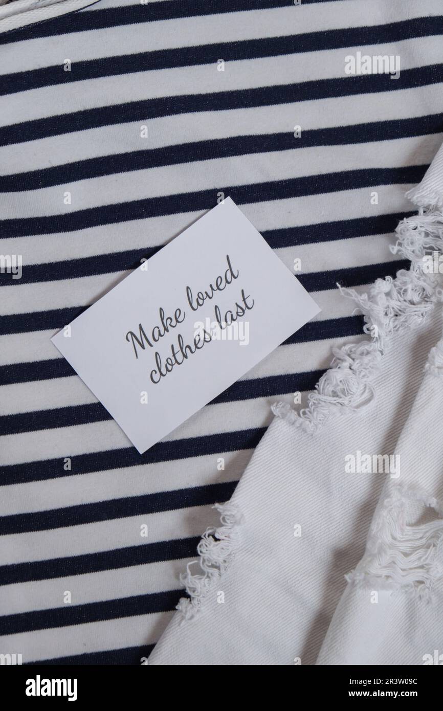 MAKE LOVED CLOTHES LAST text on paper note on clothes assortment Second ...