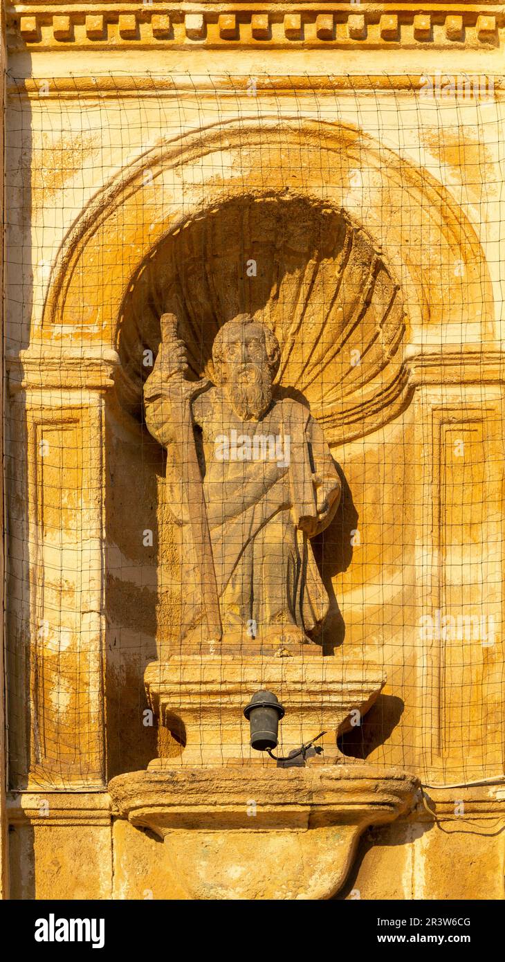 Stonework sculpture of Saint with sword in niche on front of cathedral ...