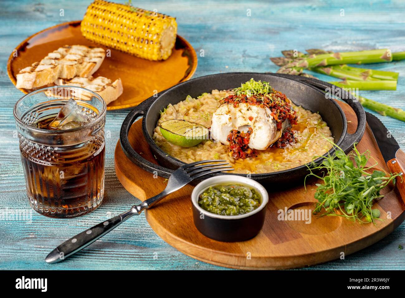 A piece of fish with sauce on a bed of rice or barley, grilled with ...