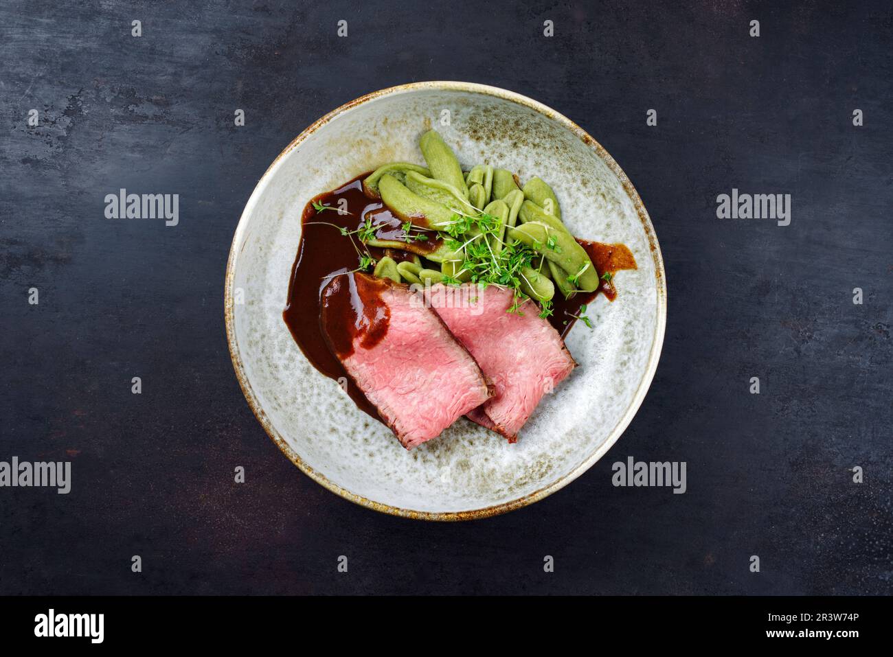 Traditional Italian chianina sliced roast beef with spinach pasta ...