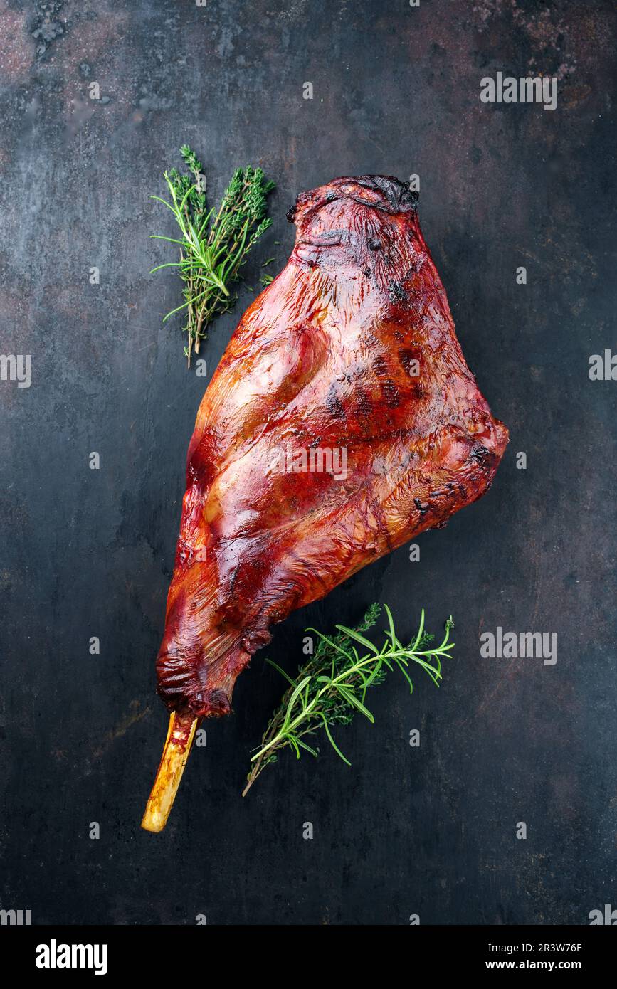 Traditional barbecue leg of venison served with herbs as top view on ...