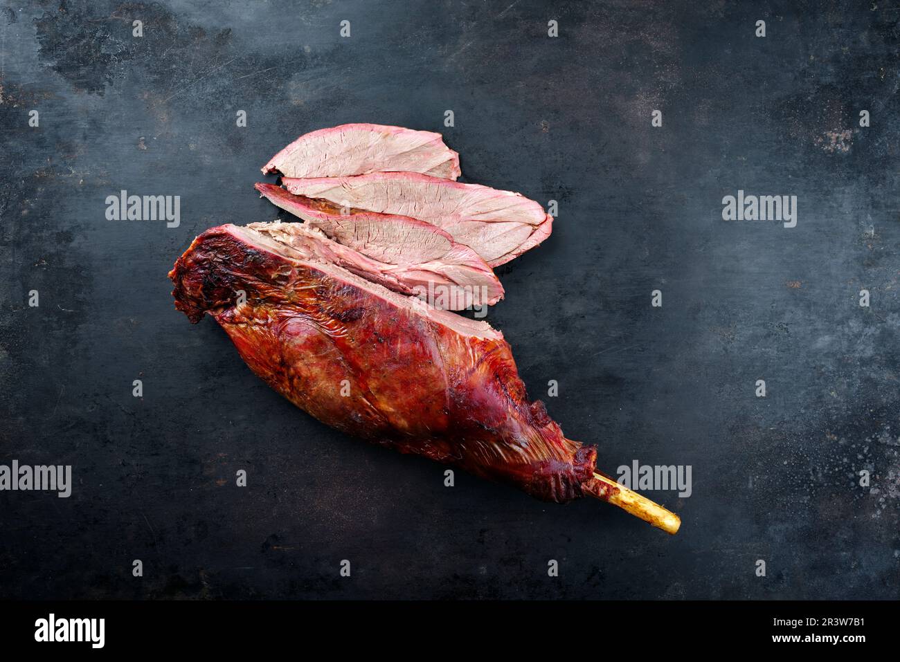 Traditional barbecue leg of venison sliced and served as top view on ...