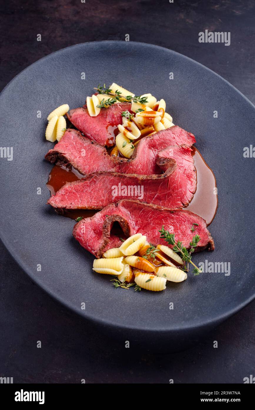 Traditional Italian chianina sliced roast beef with gnocchetti sardi ...
